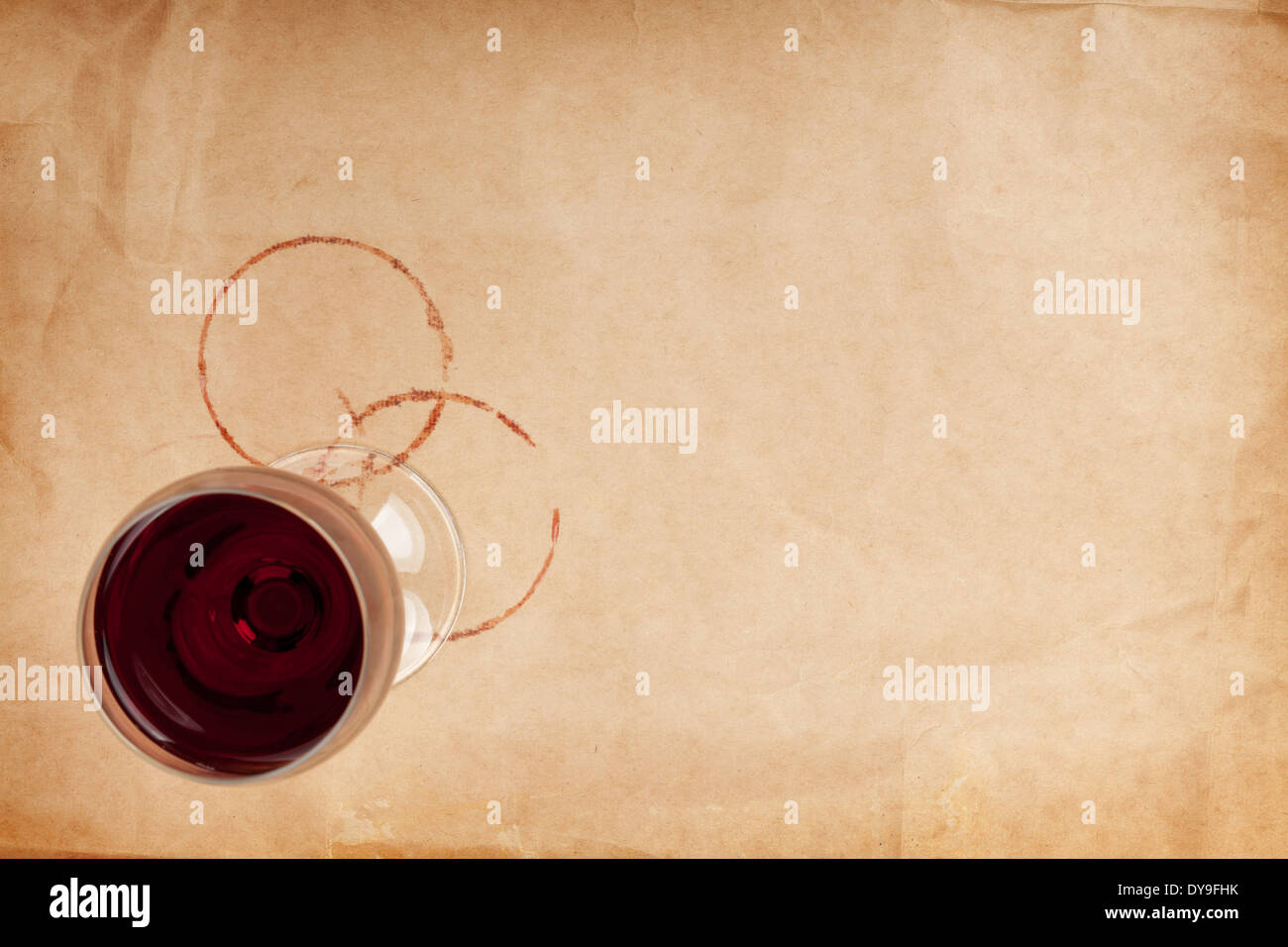 Red wine glass and stains on brown paper background with copy space ...
