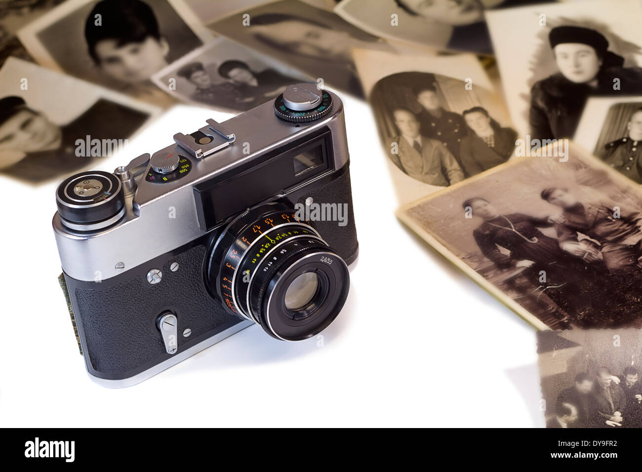 The outdated film camera and ancient black white photos on a white ...