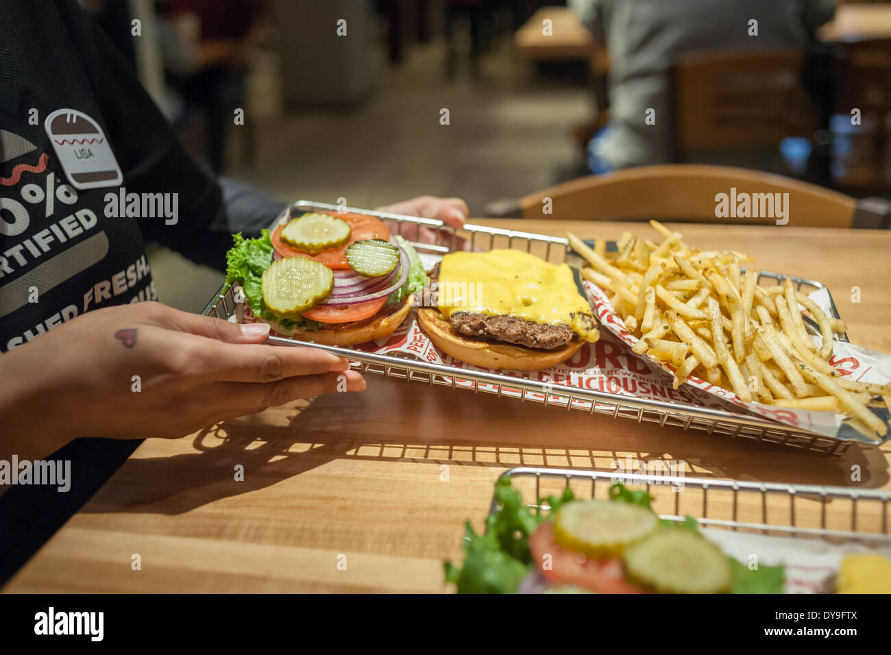 A server brings an order of a Classic Smashburger and fries to the ...