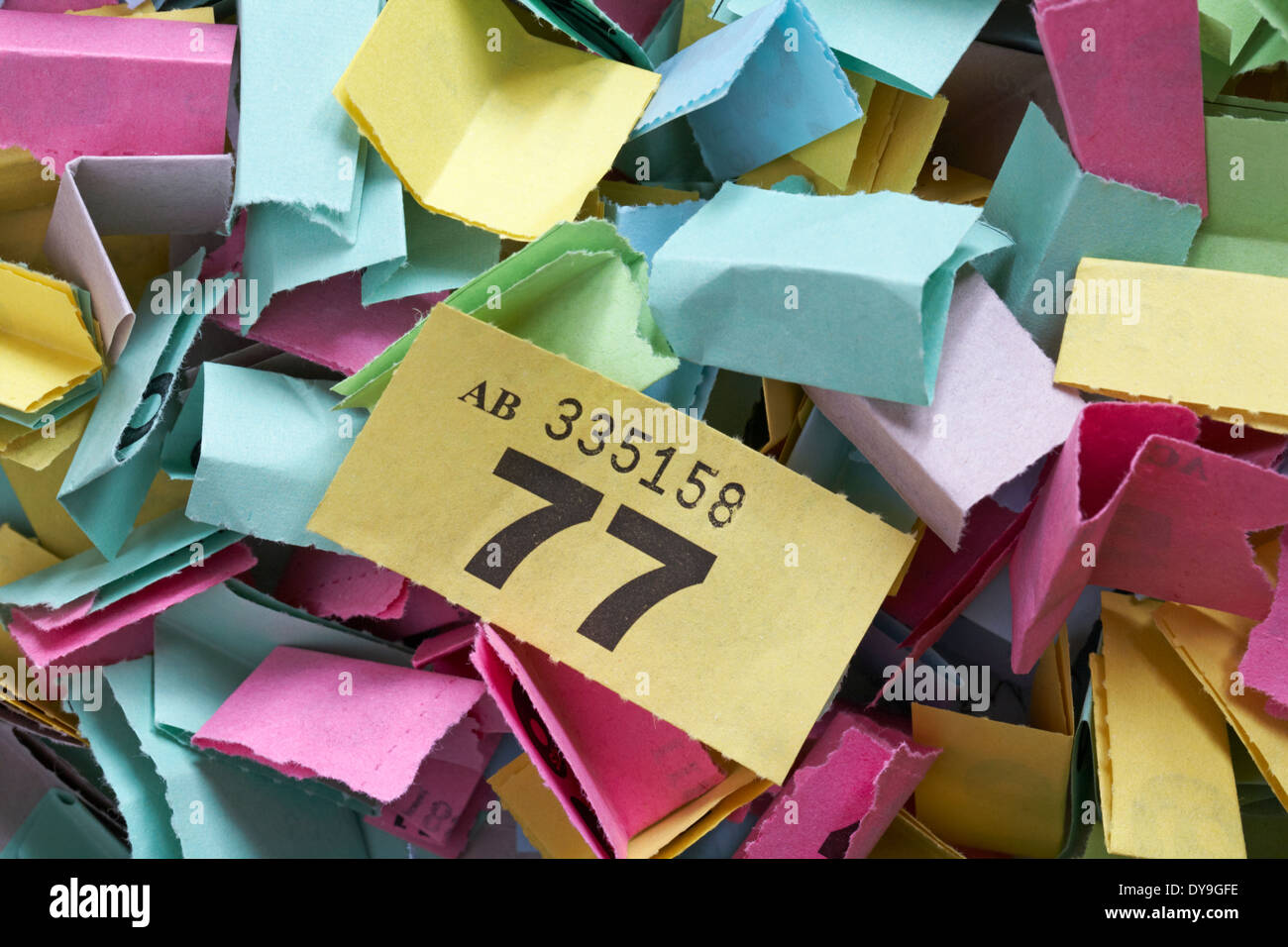 pile of different coloured raffle tickets folded up with yellow ticket ...