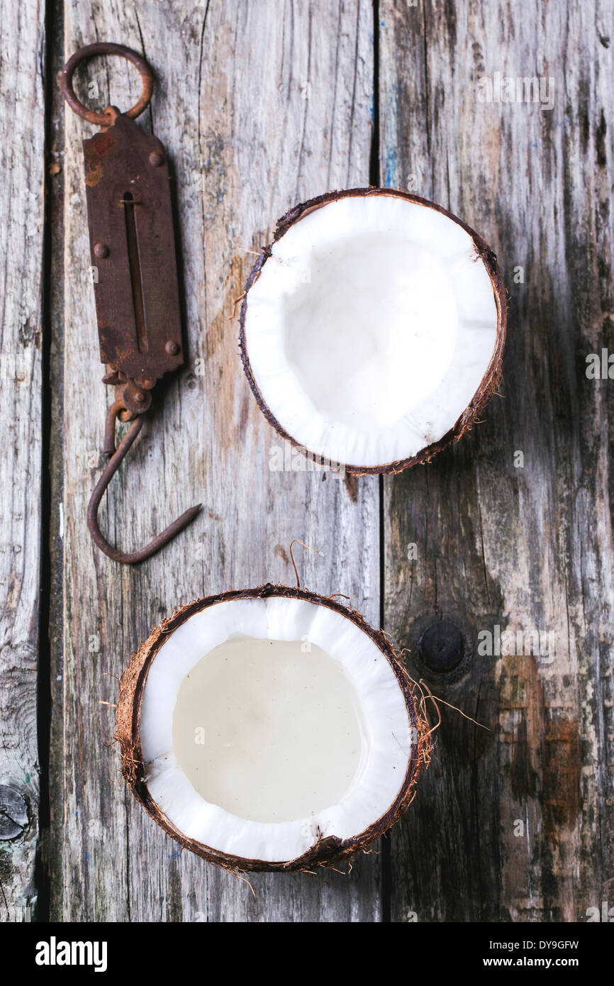 Broken coconut shell with coconut milk and vintage steelyard on old ...