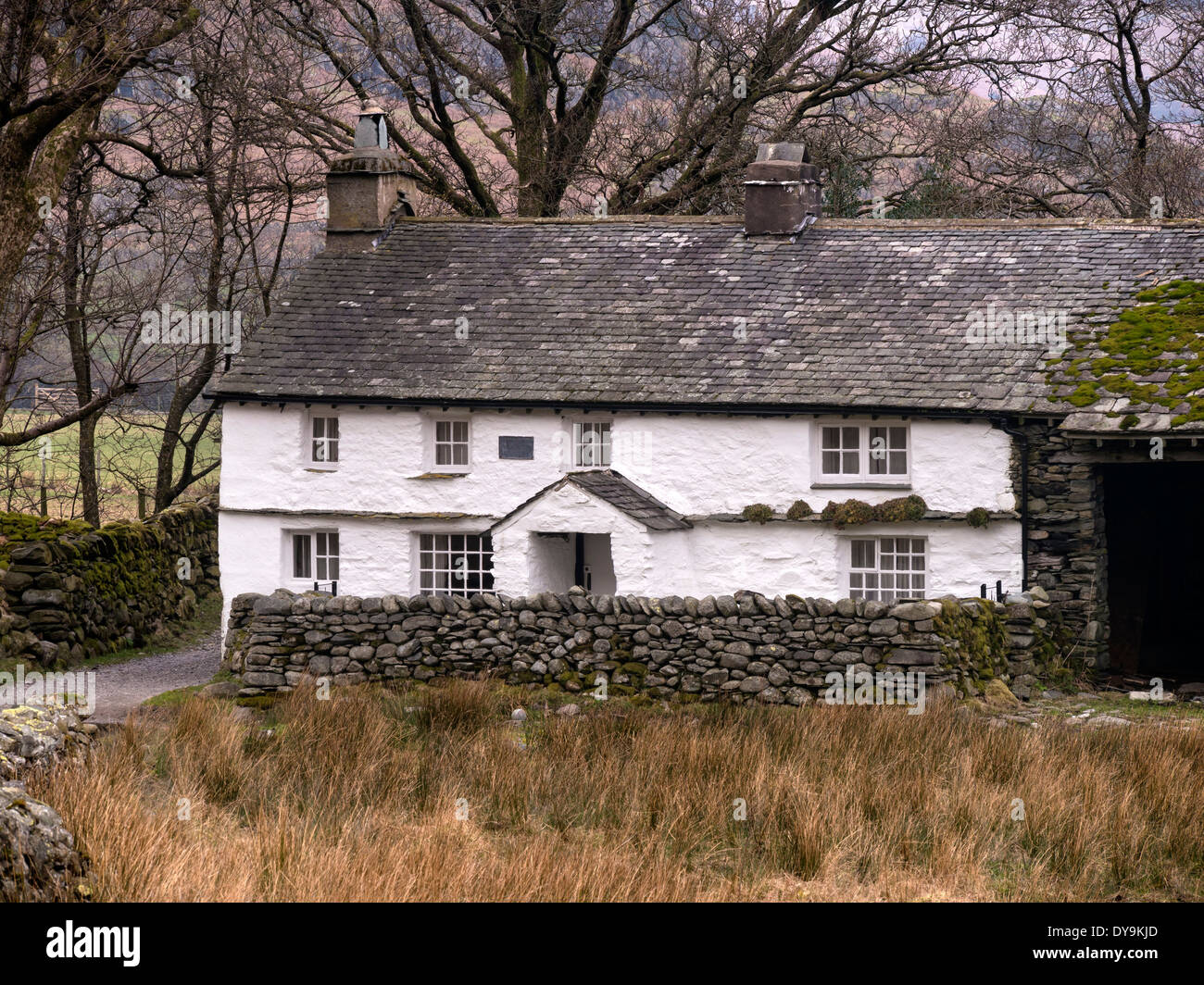 Old white washed farm cottage with slate roof and adjoining barn ...