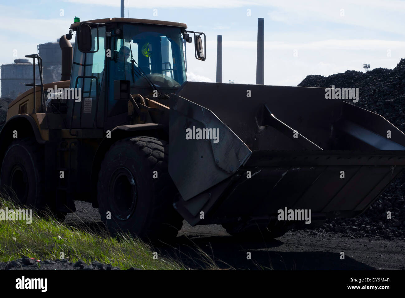 A wheeled front end bucket loader machine working in coal stocking ...