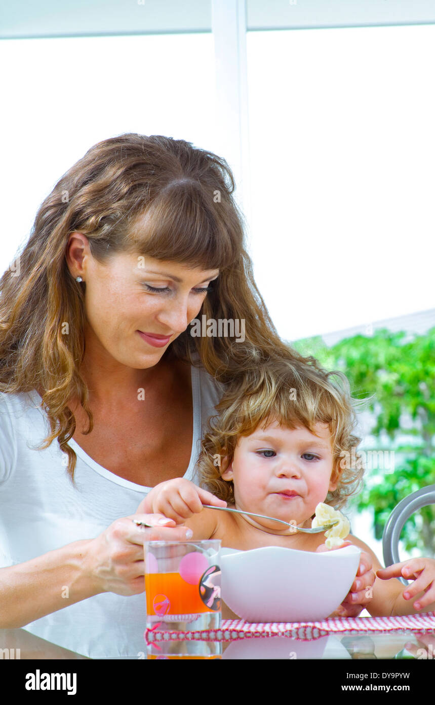 Portrait of young woman feeding her baby daughter Stock Photo - Alamy