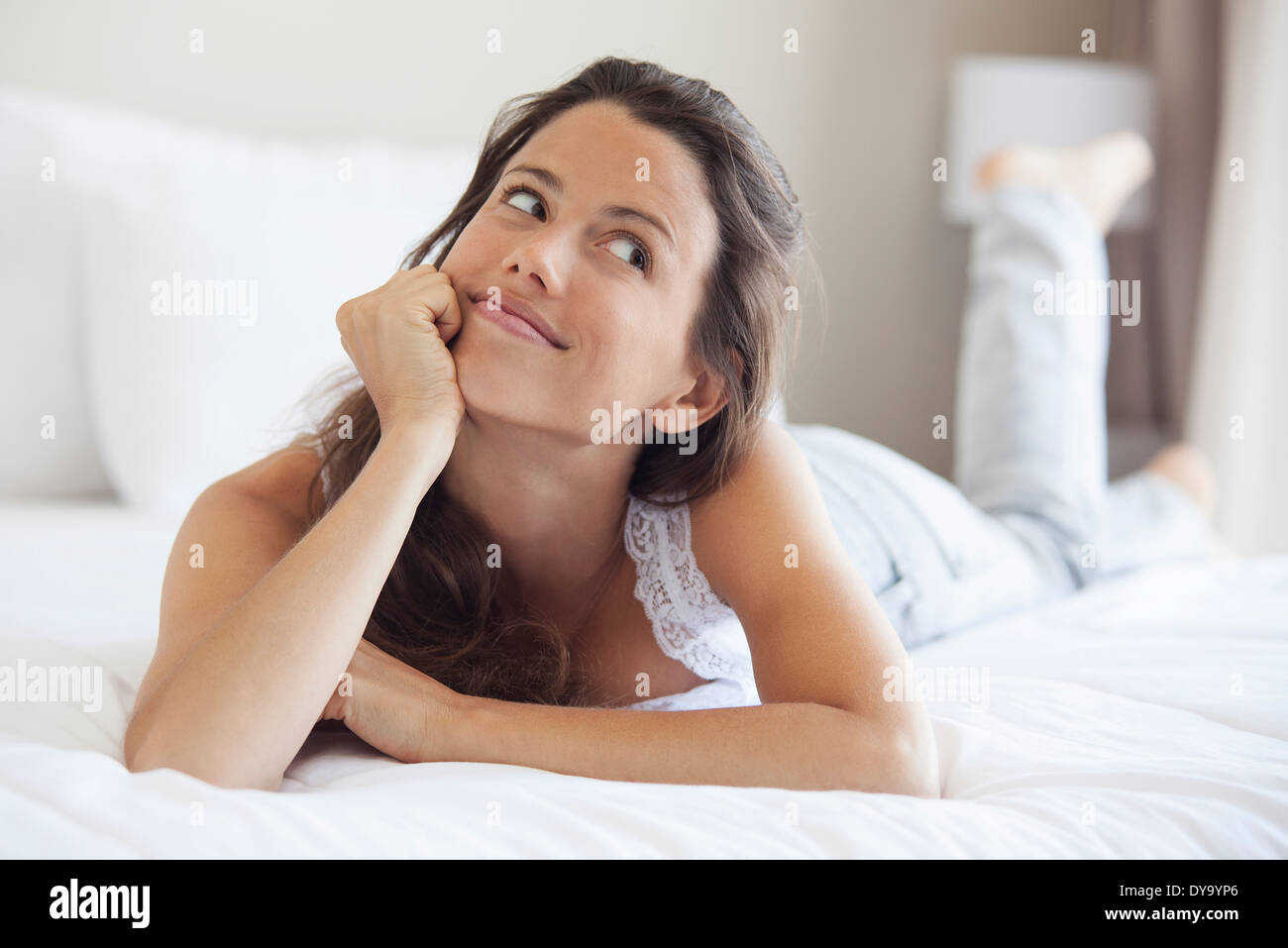Young woman lying on stomach, leaning on elbow, portrait Stock Photo ...