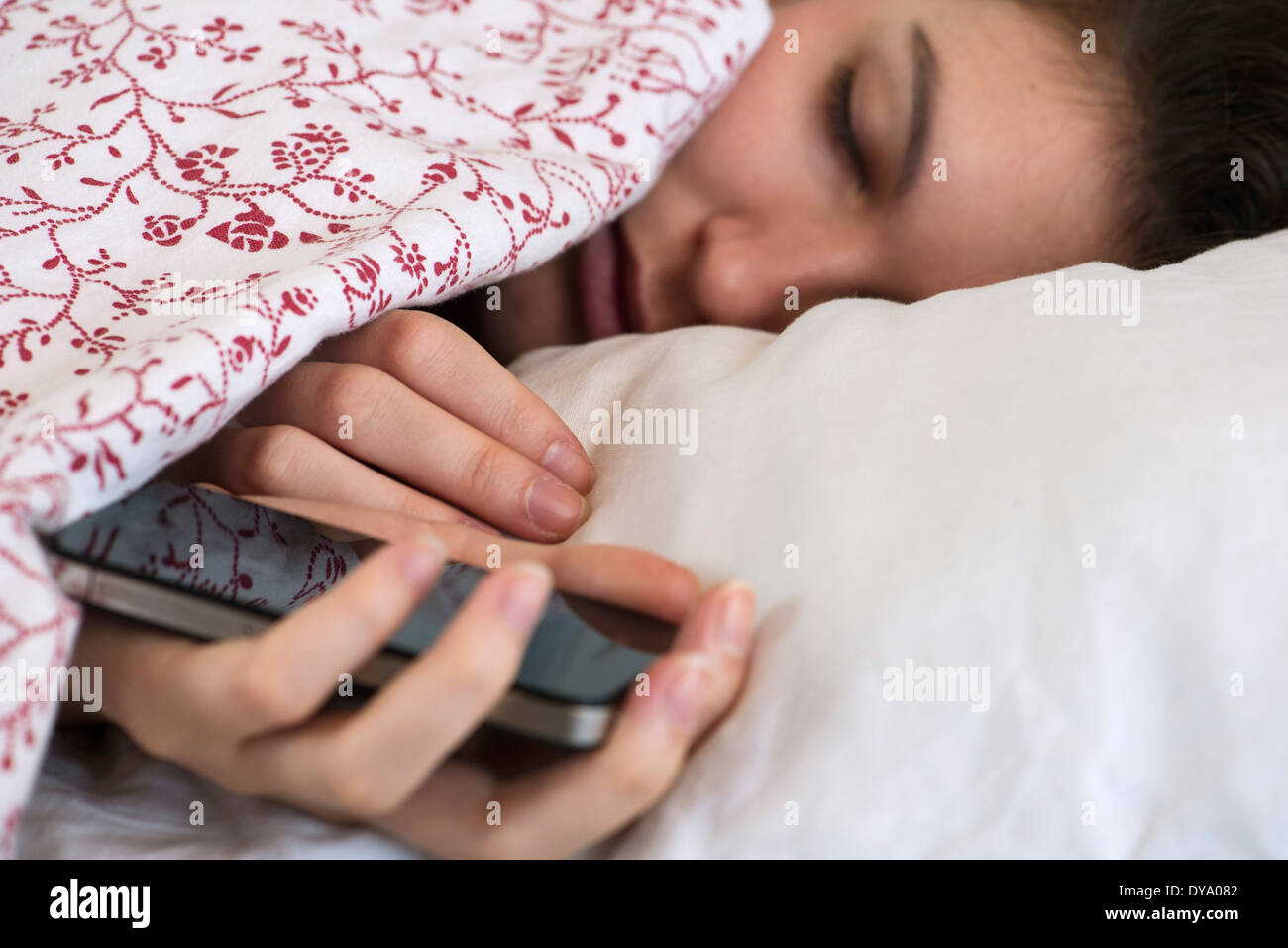 Woman sleeping in bed with smartphone in hand Stock Photo - Alamy