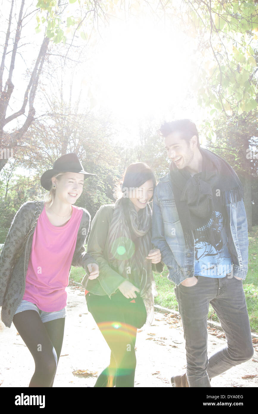 Friends walking together through park Stock Photo - Alamy
