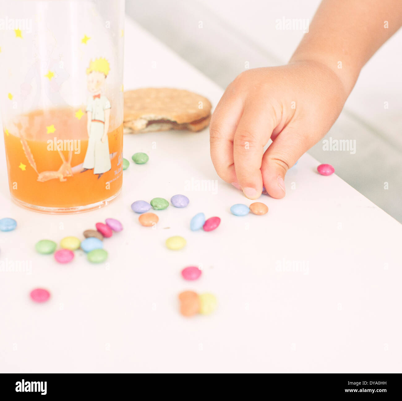 Child picking up candies from table Stock Photo - Alamy