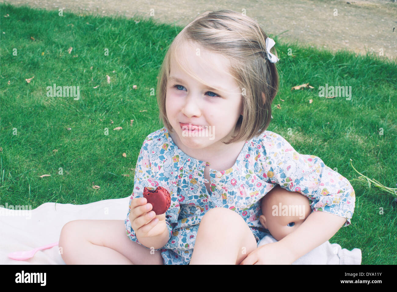 Little girl eating macaroon Stock Photo - Alamy