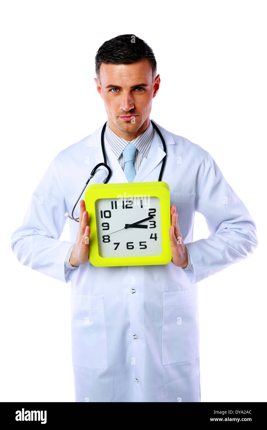 Confident male doctor holding clock isolated on white background Stock ...