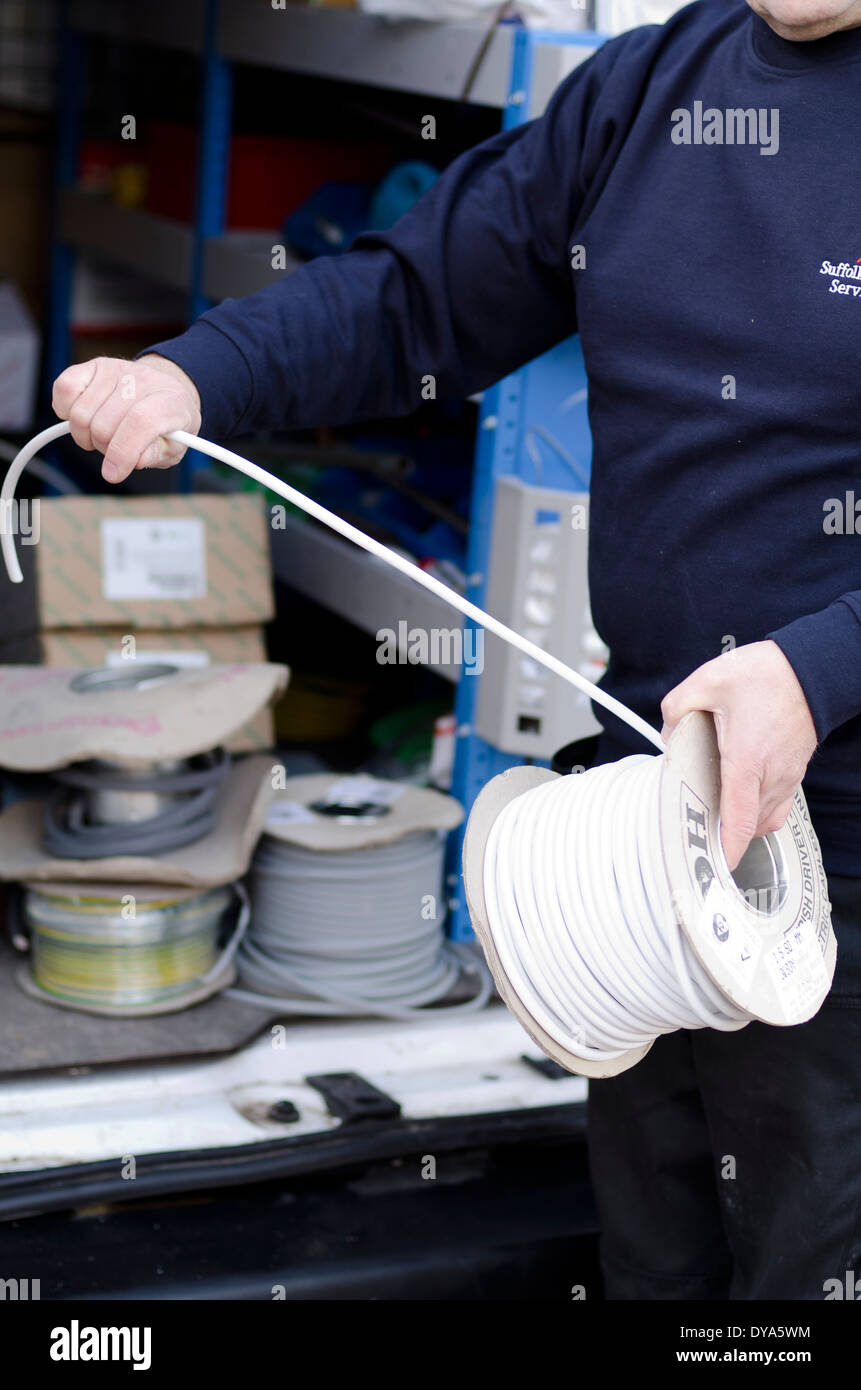 Electrician unwinding a cable at the back of his van hi-res stock ...