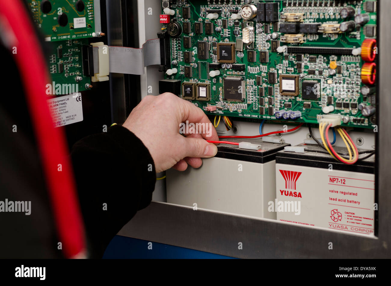 Hand connecting cable to battery on large circuit board hi-res stock ...