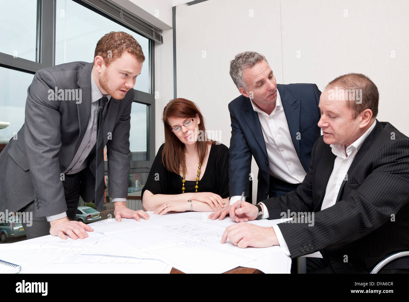 Four Business people round a meeting room table Stock Photo - Alamy