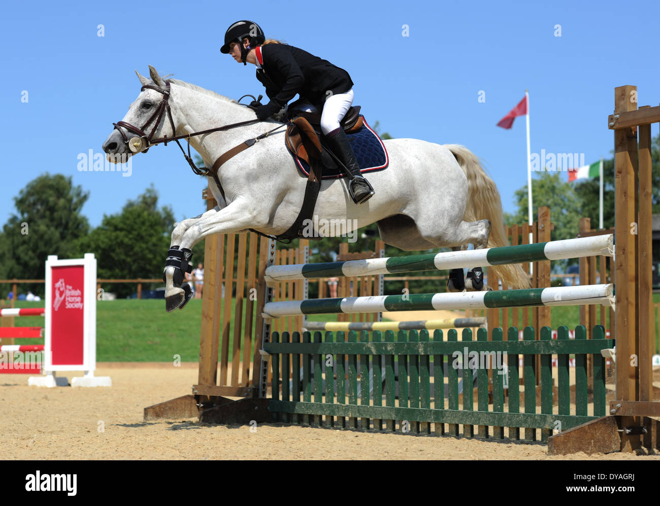 A Rider jumps a fence on her horse during a show jumping competition ...
