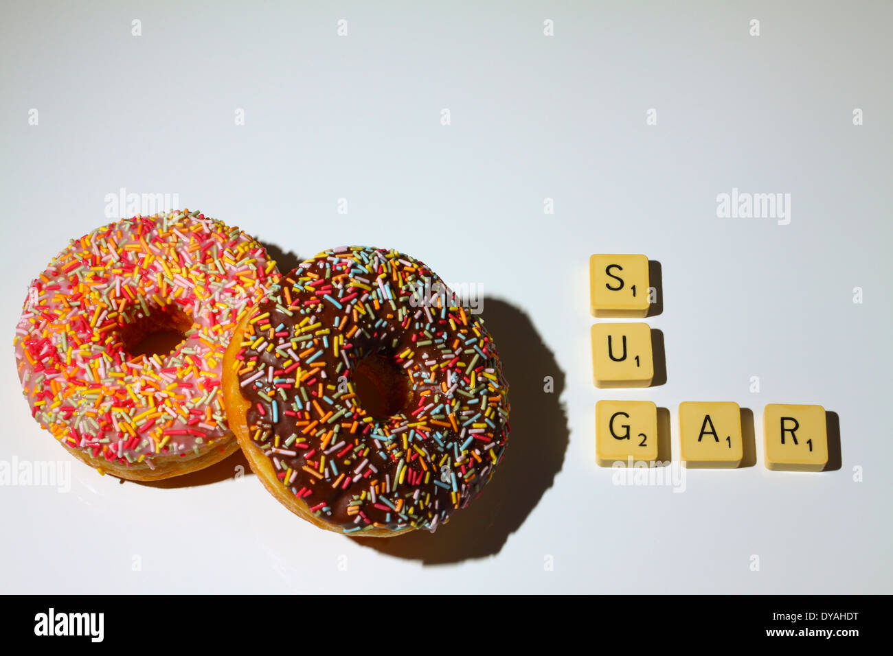 Iced doughnuts on a white background with scrabble letters spelling out ...