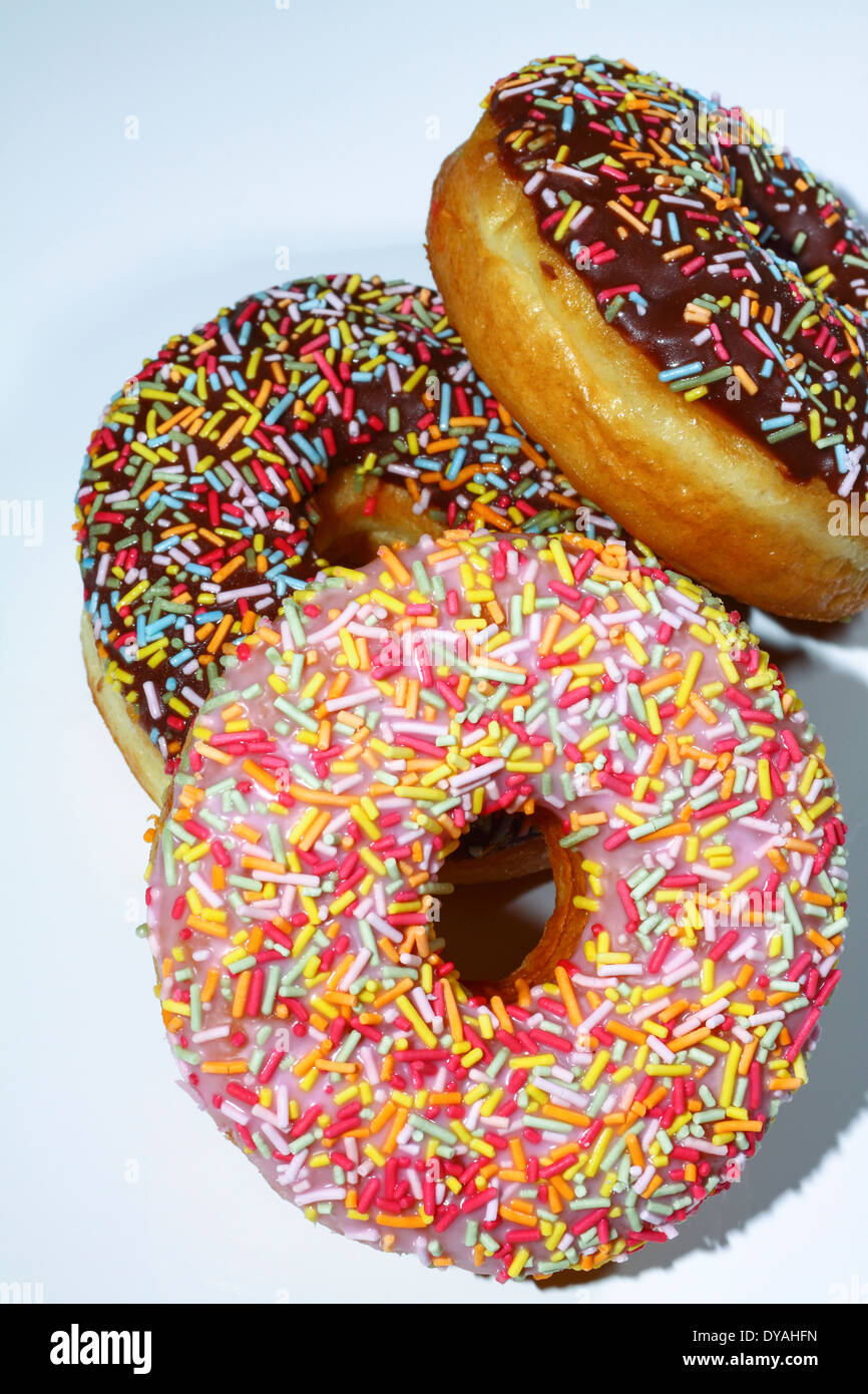Doughnuts with icing and sprinkles on a white background Stock Photo ...