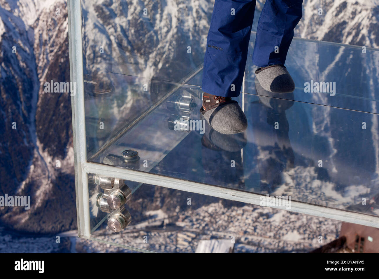 A tourist stands in the 'Step into the Void' glass box on the Aiguille ...