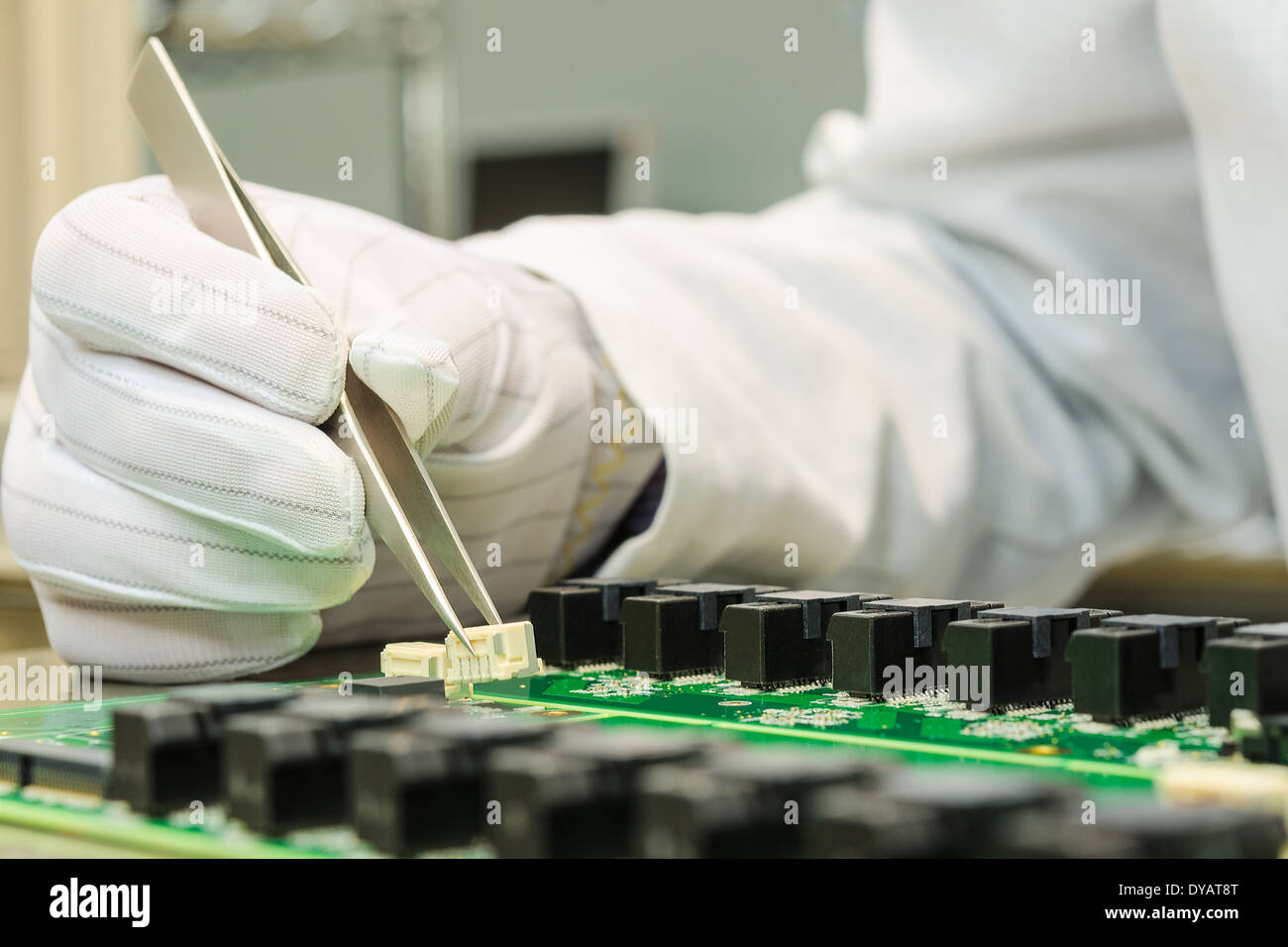 Female hand holding tweezers and installing connector on PCB in turnkey ...