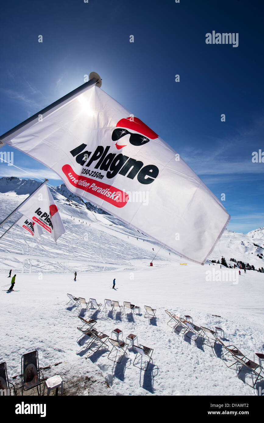 Flags waving outside mountain ski resort restaurant above Belle Plagne ...