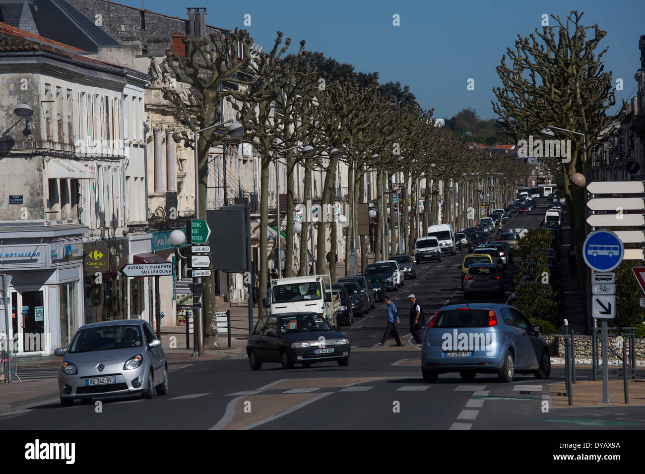 Main street lined with trees in medium sized town Stock Photo - Alamy