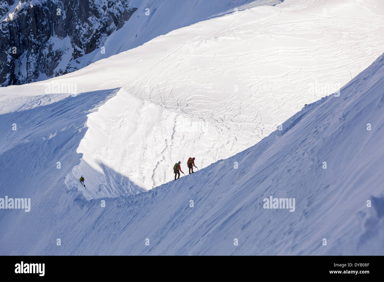Mountaineers and a skier descend from a lookout point on the Aiguille ...