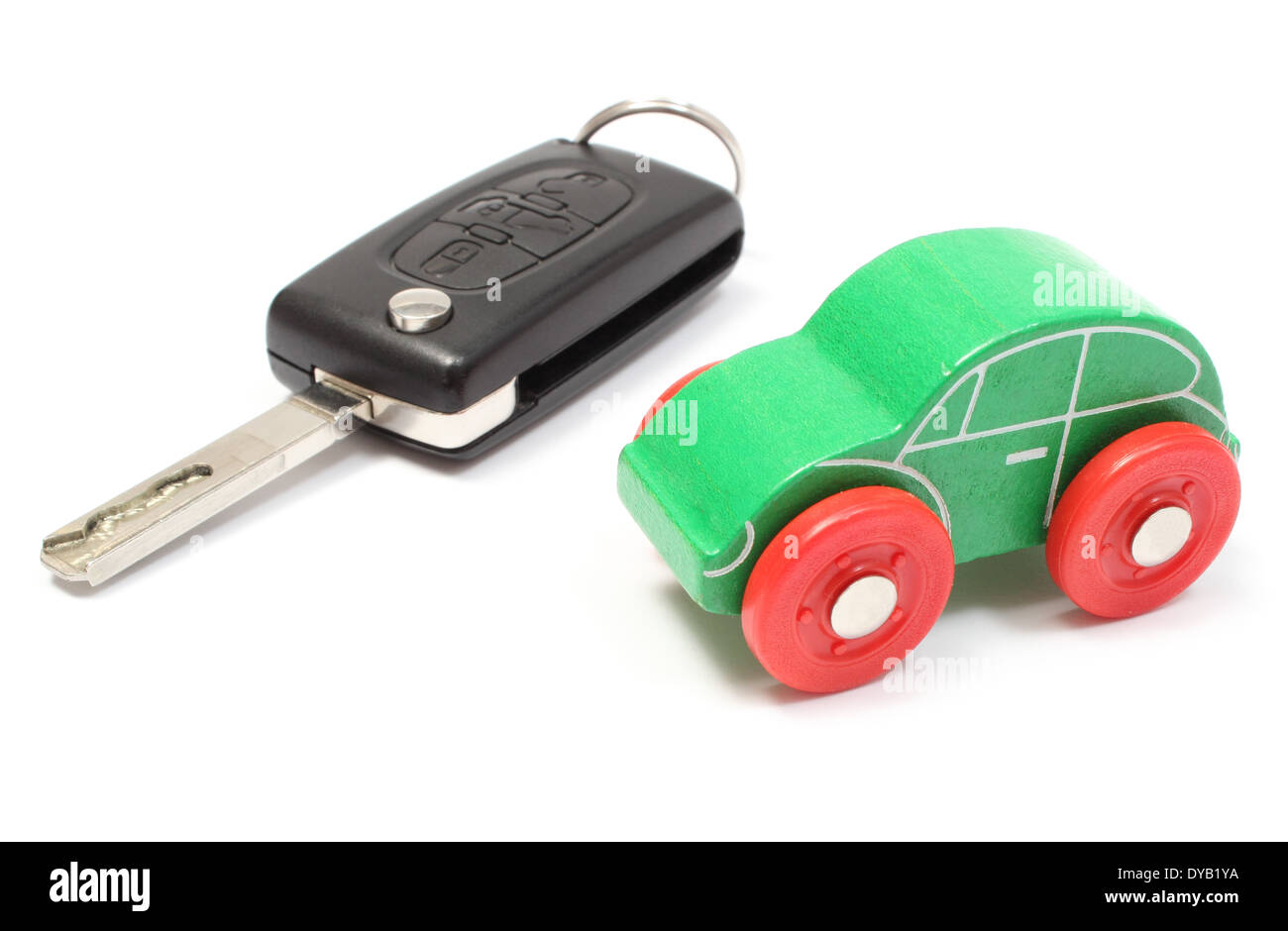Closeup of wooden green toy car and car key, vehicle key. Isolated on ...