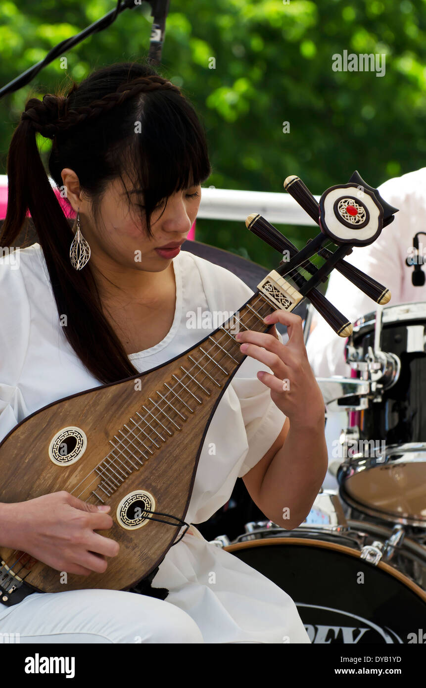 Girl playing Chinese stringed instrument at the Mardi Gras, part of the ...