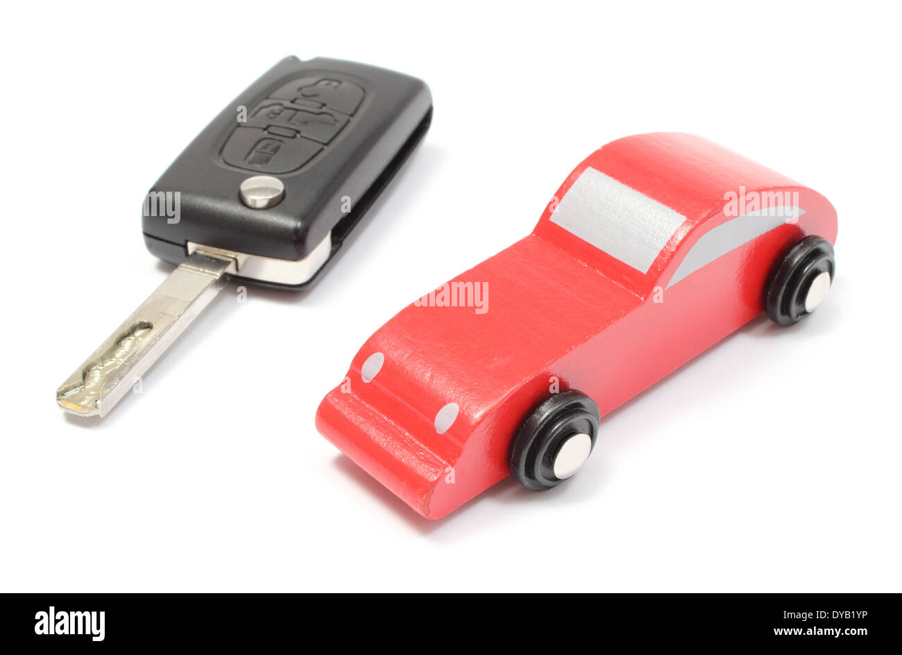 Closeup of wooden red toy car and car key, vehicle key. Isolated on ...