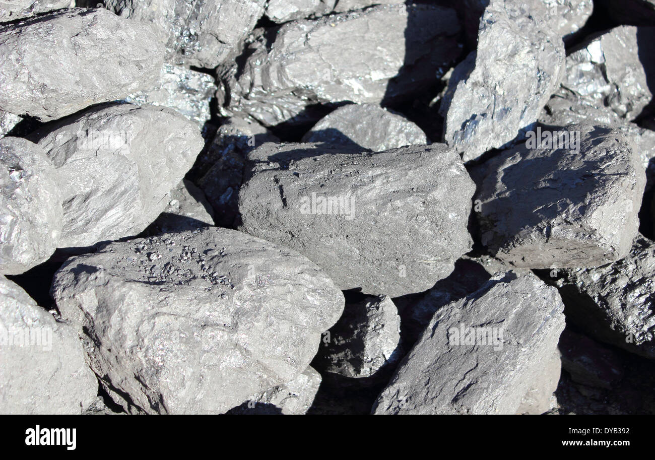 Stack of large and black coal lumps prepared for winter in sunny day ...
