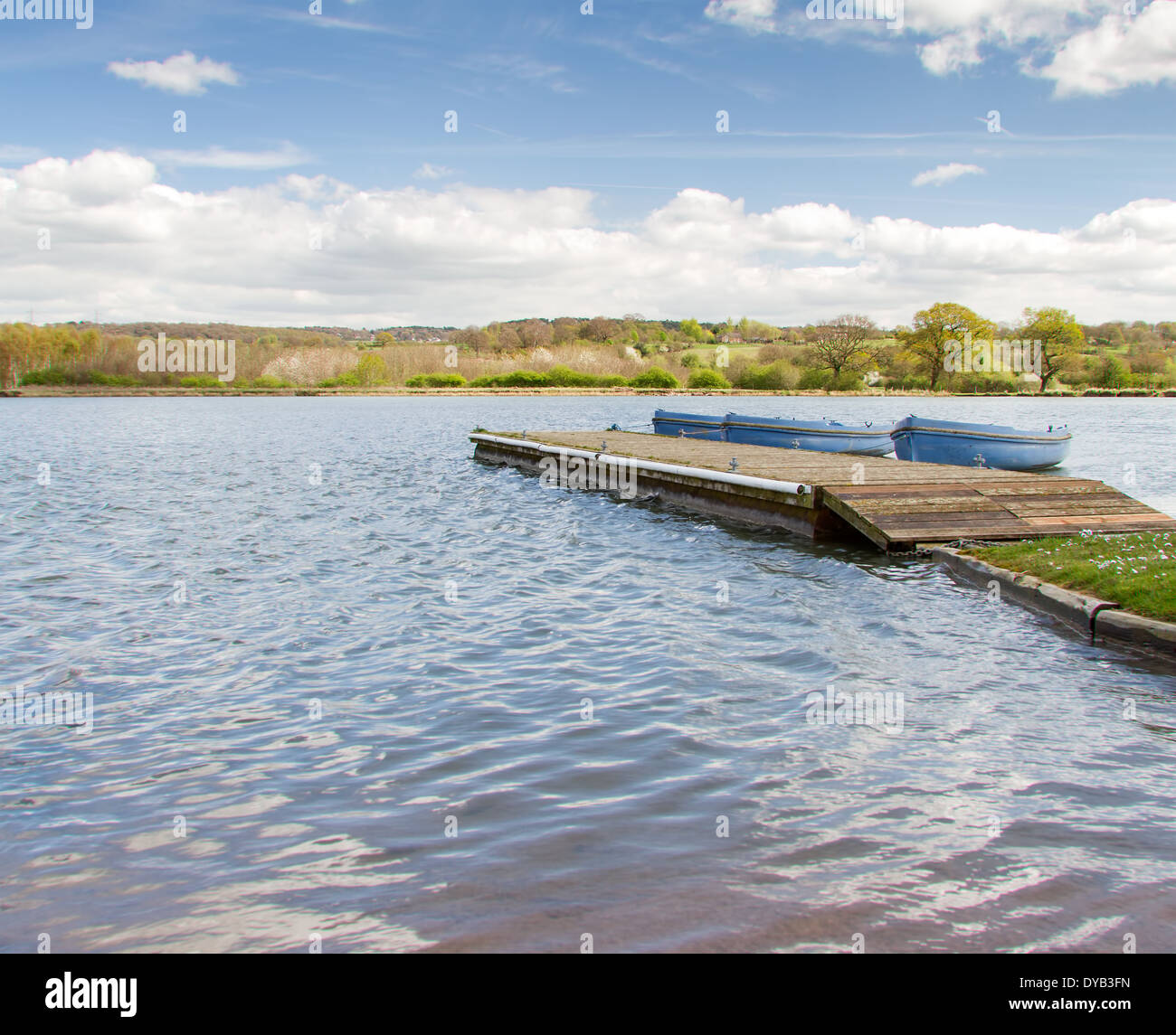 Small boats tied to a wooden lake jetty Stock Photo - Alamy