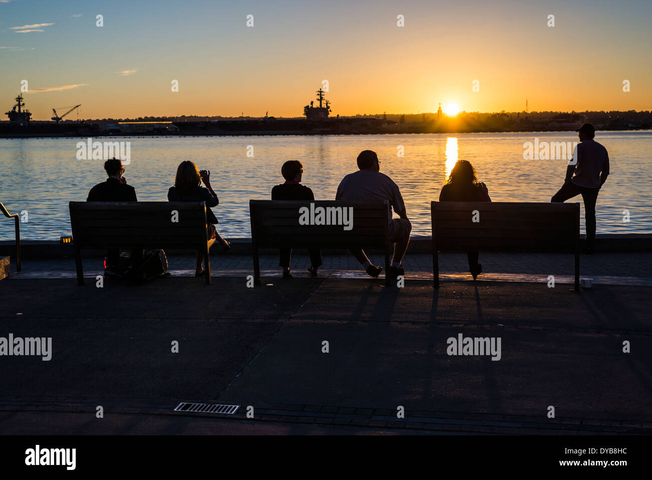 People watching the setting Sun from benches at Tuna Harbor Park. San ...