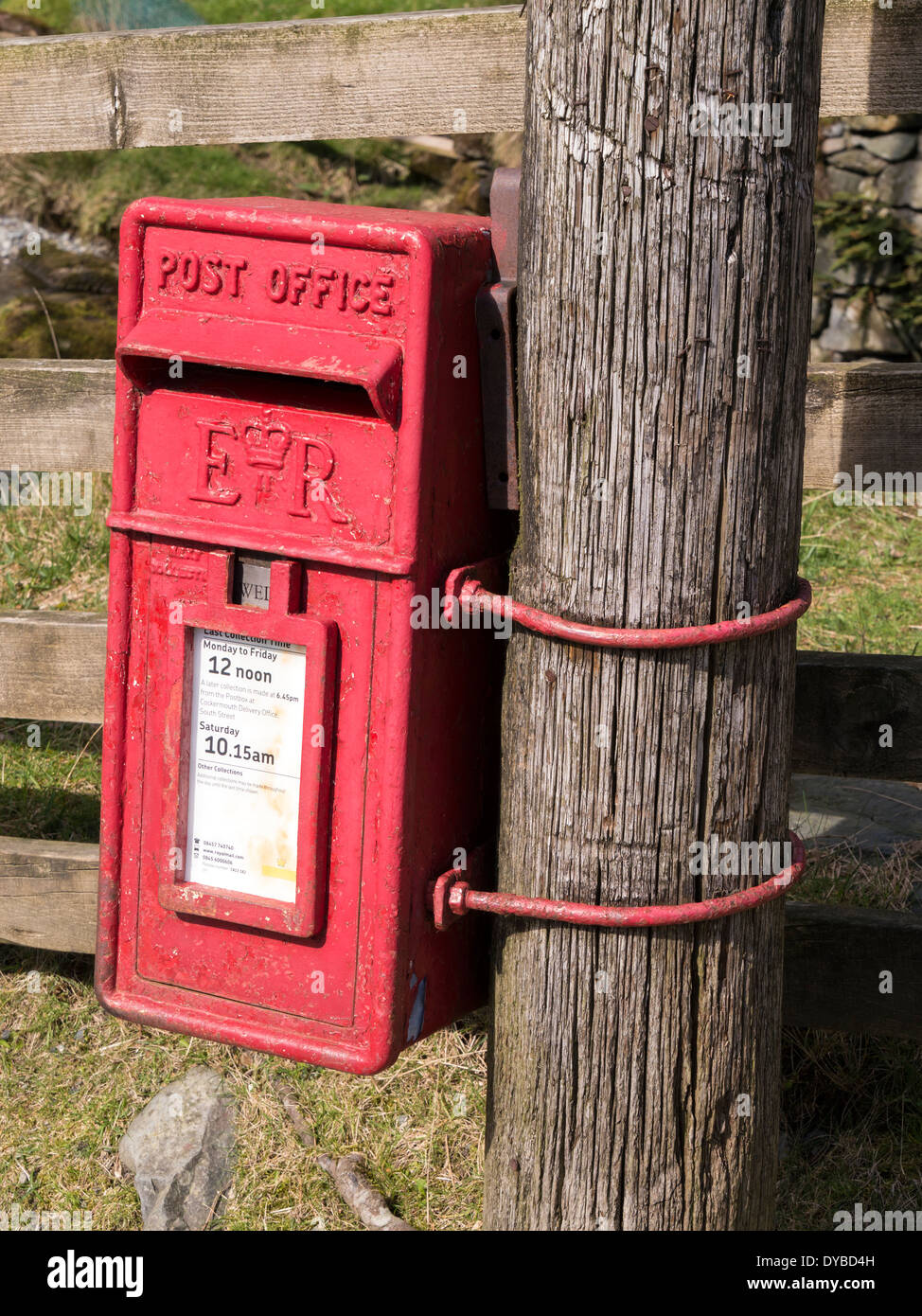 Rural bright red Post Office postal Box fixed to wooden post in English ...