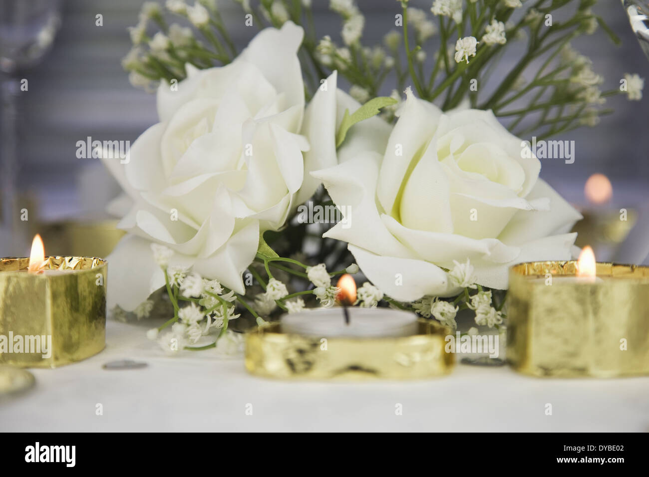 wedding table decoration with fake roses and gold colour candles Stock ...