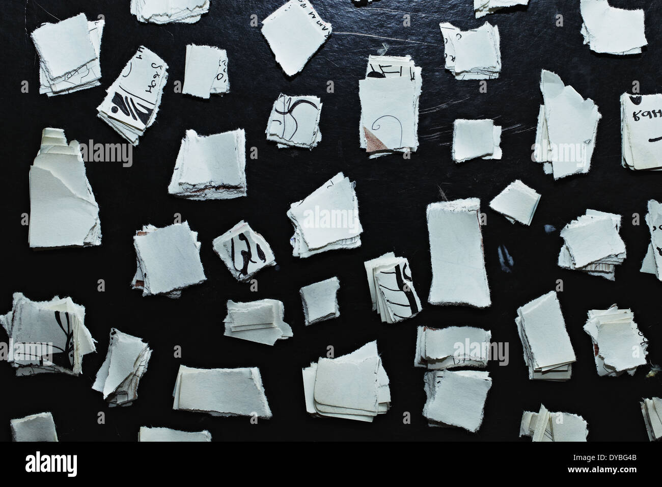 Black background with snippets of white paper closeup Stock Photo - Alamy