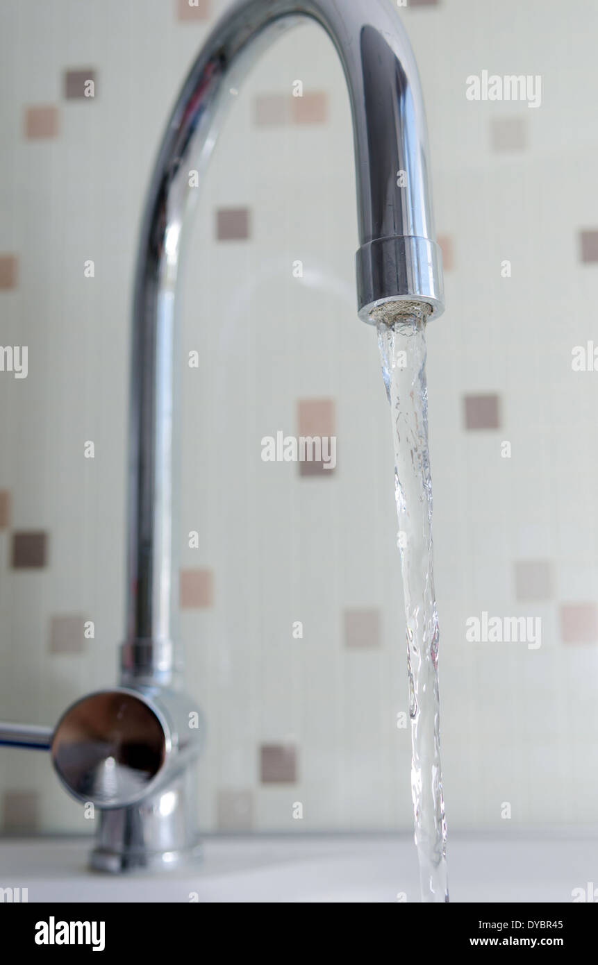 Pouring water from a tap in a bathroom Stock Photo - Alamy