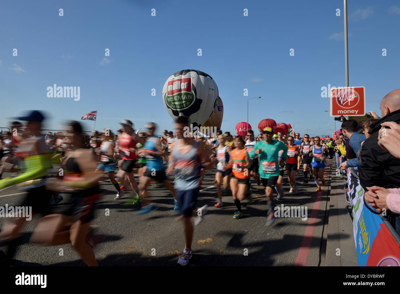London, UK. 13th Apr, 2014. Runners and spectators crowd the streets ...