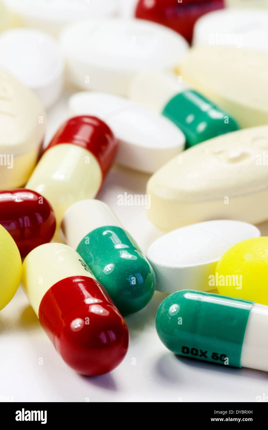 Antibiotics - a mixture of antibiotic capsules and tablets on a white ...