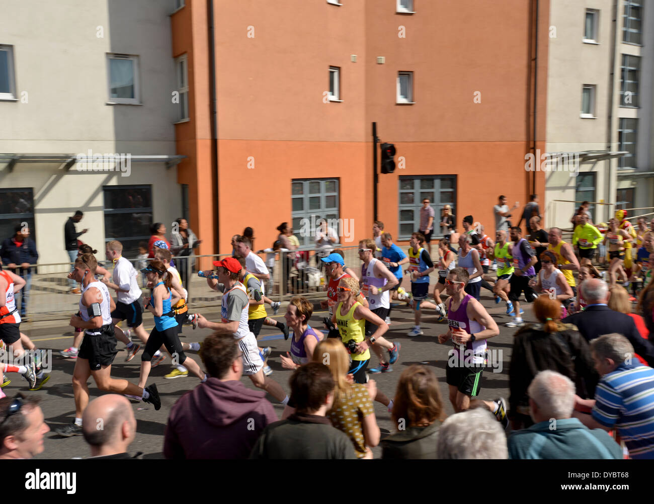 London, UK. 13th Apr, 2014. Runners and spectators crowd the streets ...