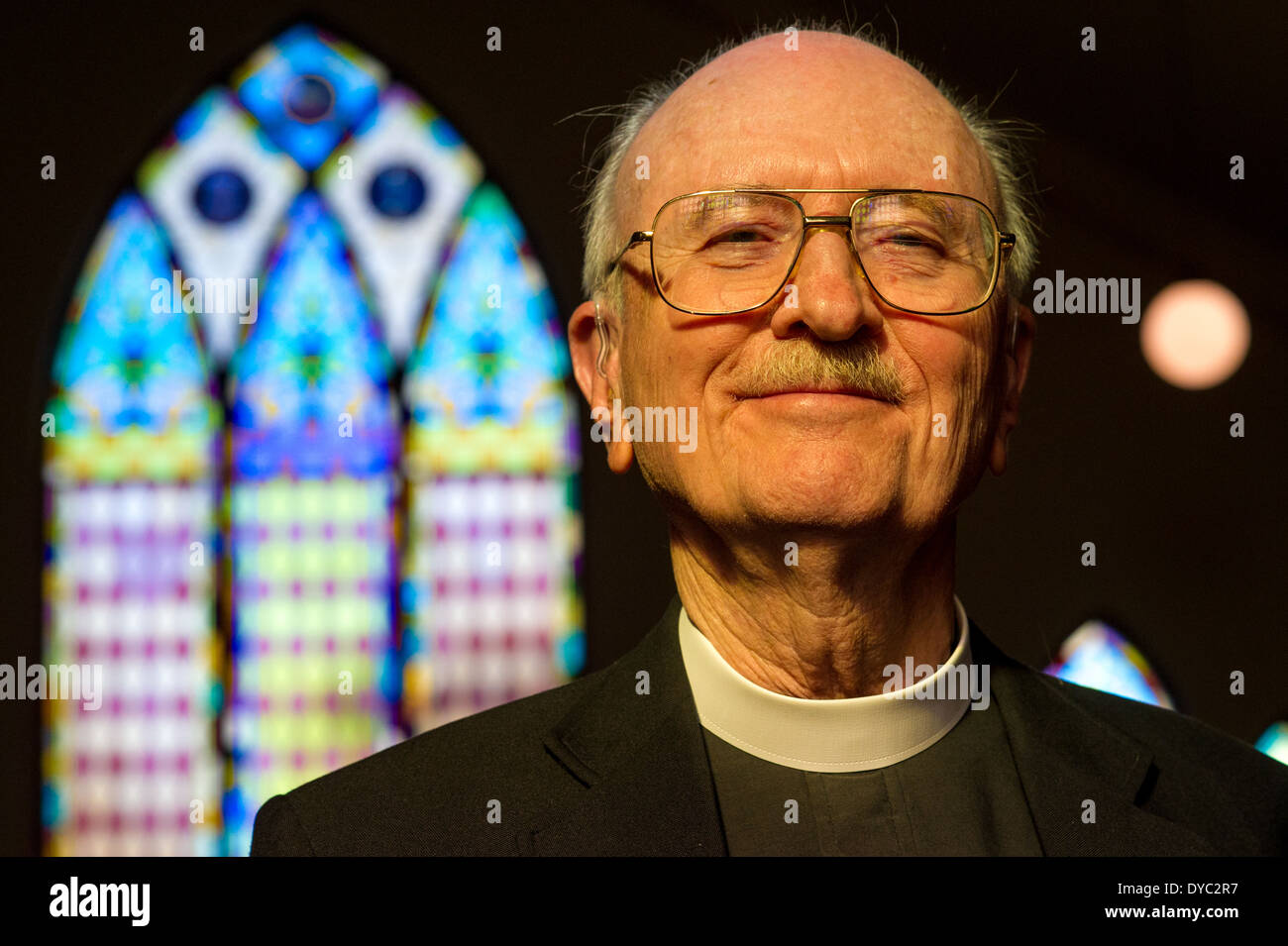 Pastor in church with stained glass windows Stock Photo - Alamy