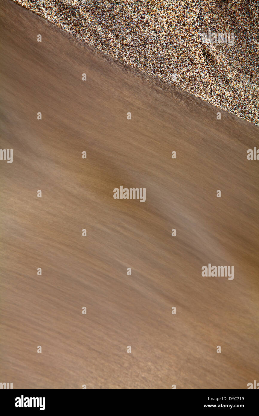 Moving water against sand Stock Photo - Alamy