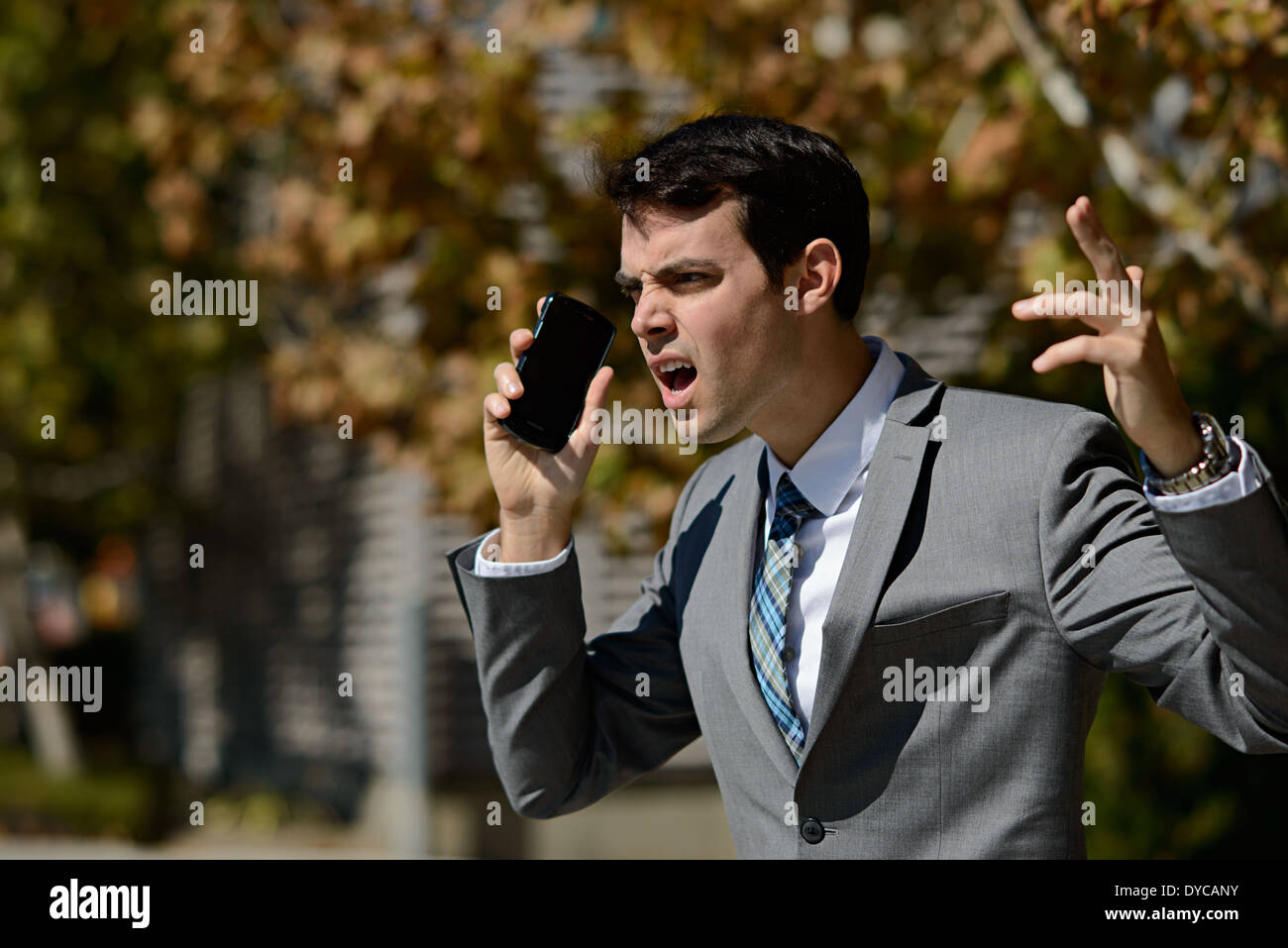 A young business man in business suit shouting angrily at someone,arms ...