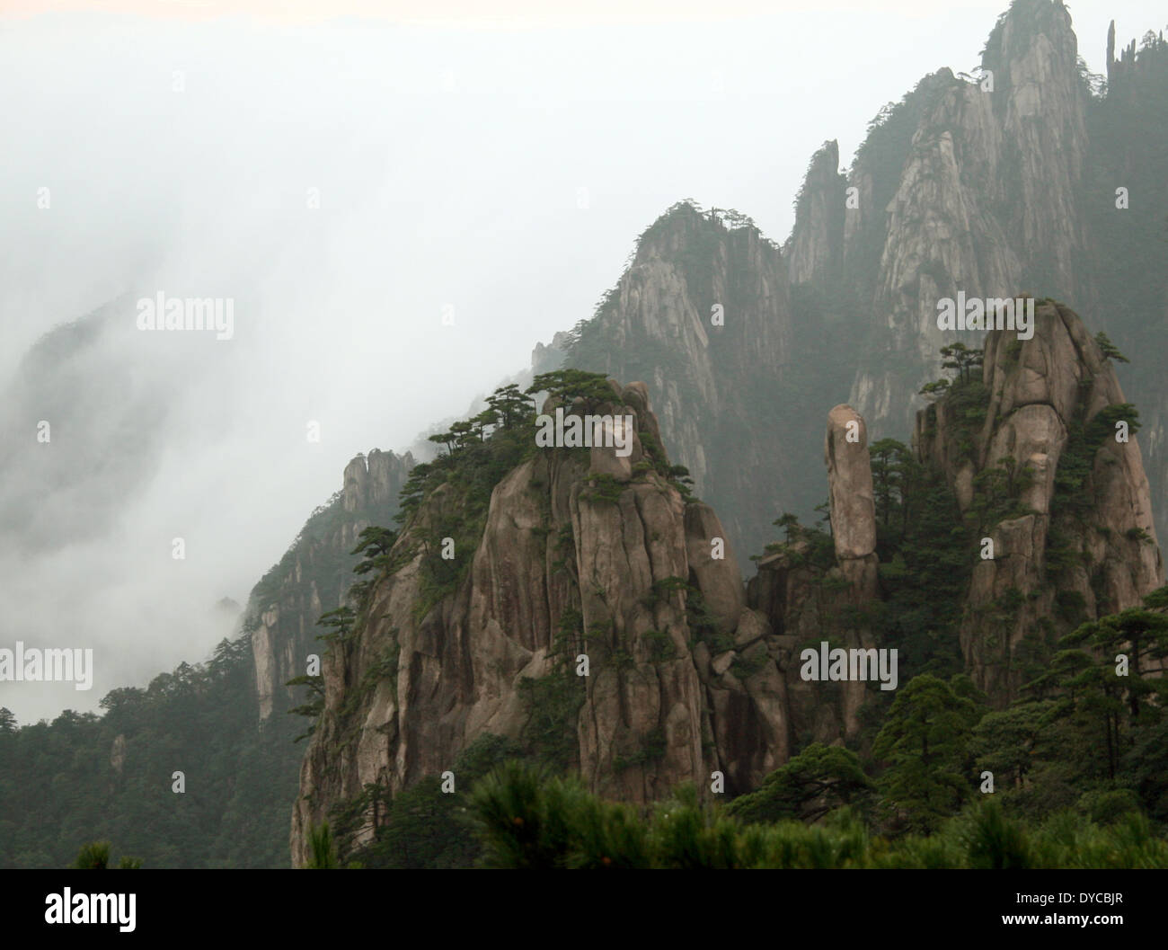 Mountain cliffs peak through the misty clouds in the Huang Shan ...
