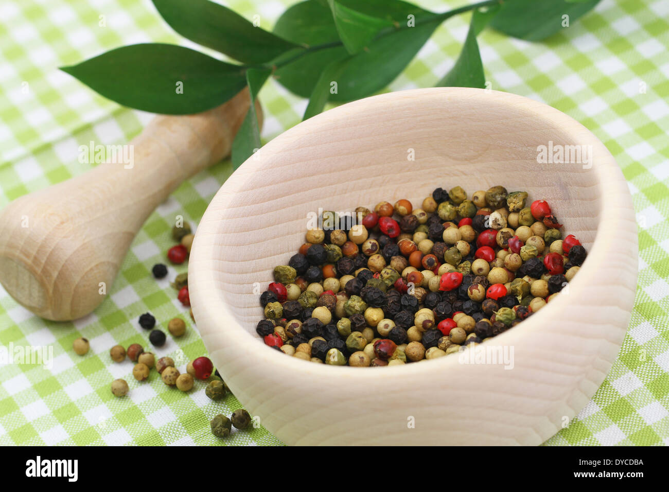 Mortar and pestle with mixed peppers on green checkered cloth Stock ...