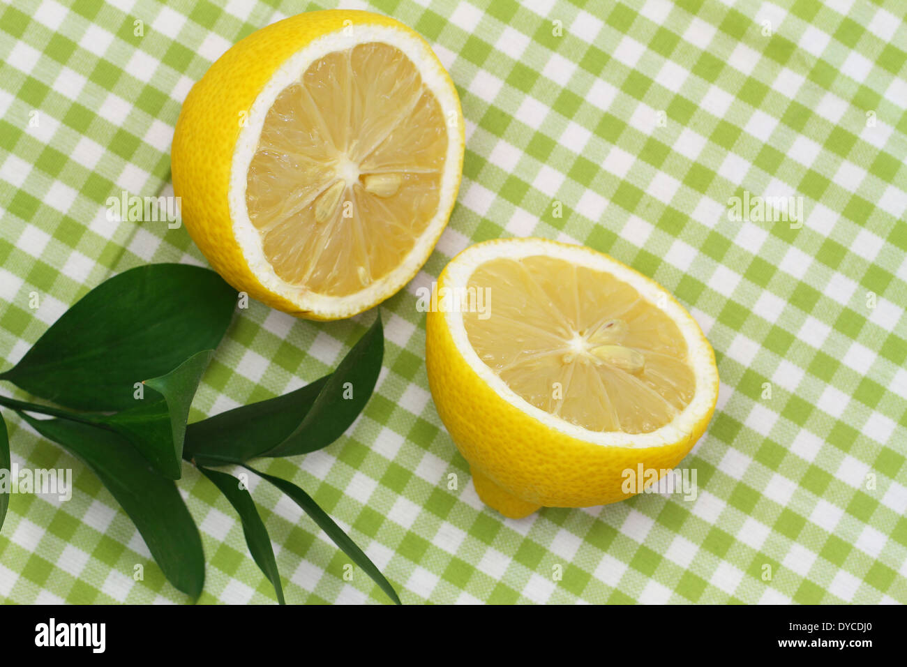 Lemon halves on green checkered cloth with copy space Stock Photo - Alamy