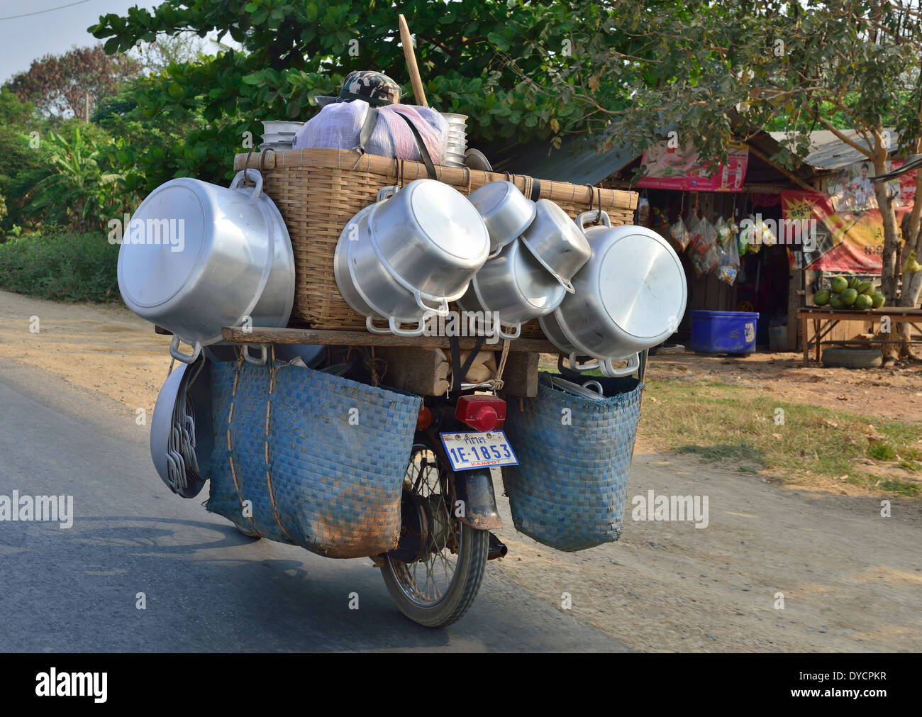Cambodian man on a small motorcycle overloaded (by european standards ...
