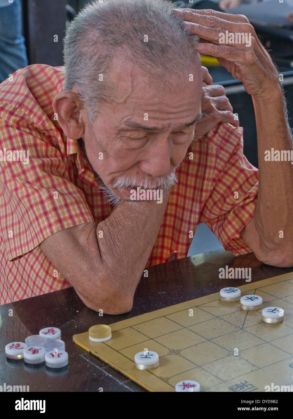 Senior Chinese man playing board game in Chinatown, Singapore Stock ...