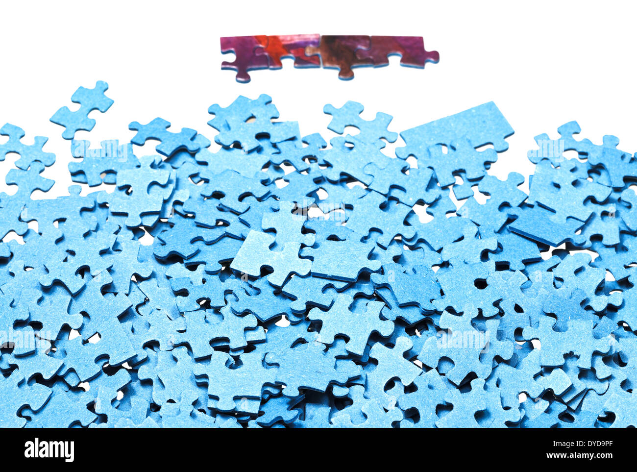 few connected pieces near of pile of jigsaw puzzles isolated on white ...