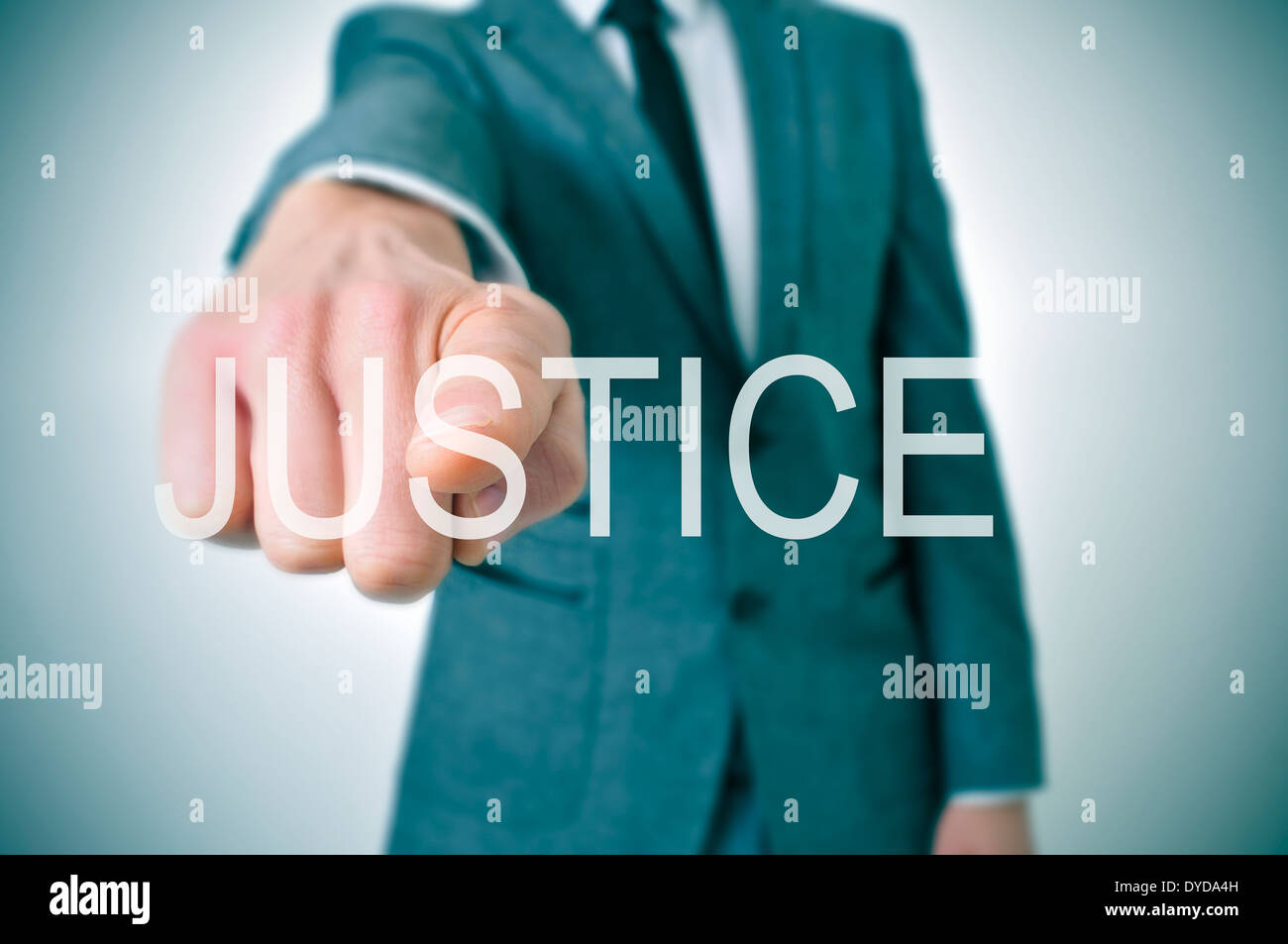 man wearing a suit pointing the finger to the word justice written in ...