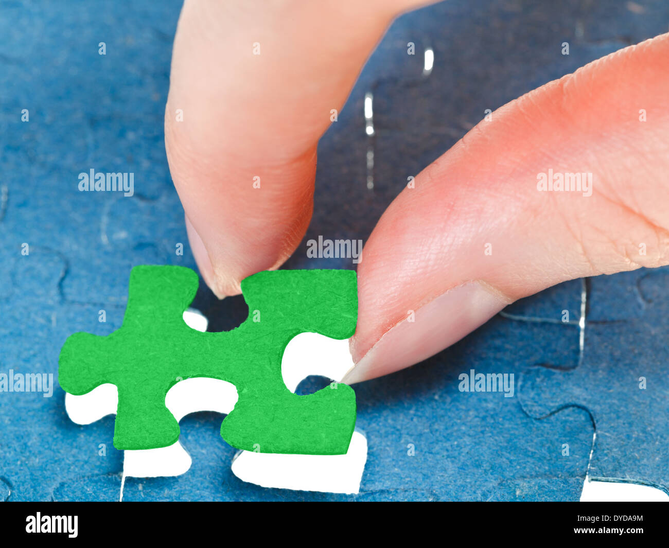 fitting the last green piece of puzzle in free space in assembled ...