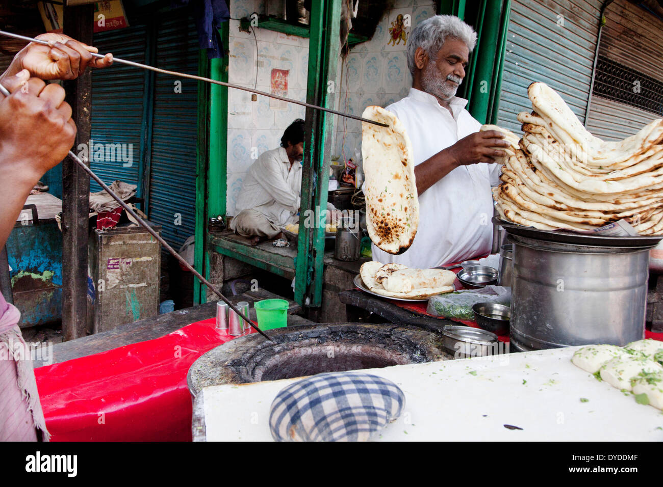 An Indian man making chapati in a street restaurant in Khari Baoli ...